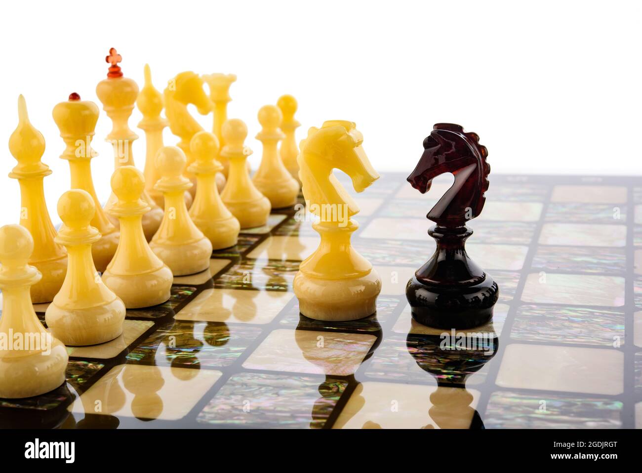 Natural amber different chess pieces figures standing on pearl board in ...