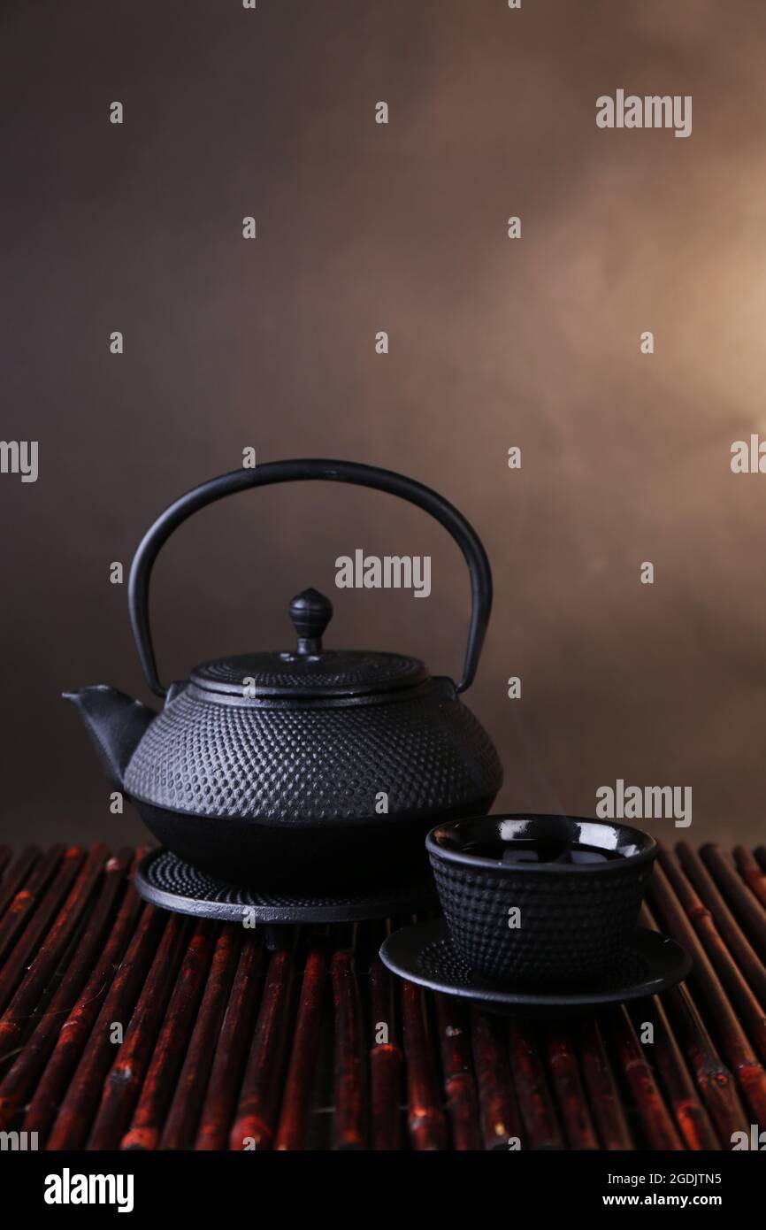 Chinese traditional teapot on bamboo mat, on dark color background ...
