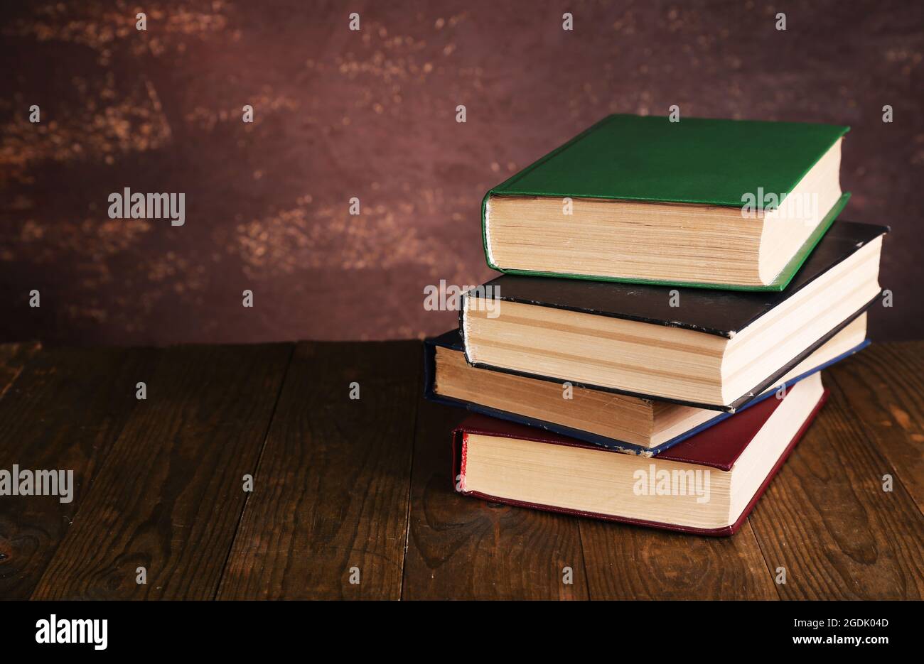 Books on wooden table on dark background Stock Photo - Alamy