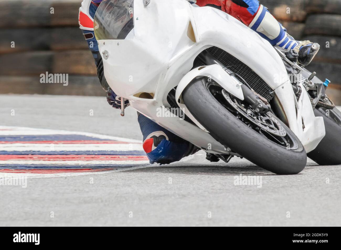 Racing bike rider leaning into a fast corner on track Stock Photo - Alamy