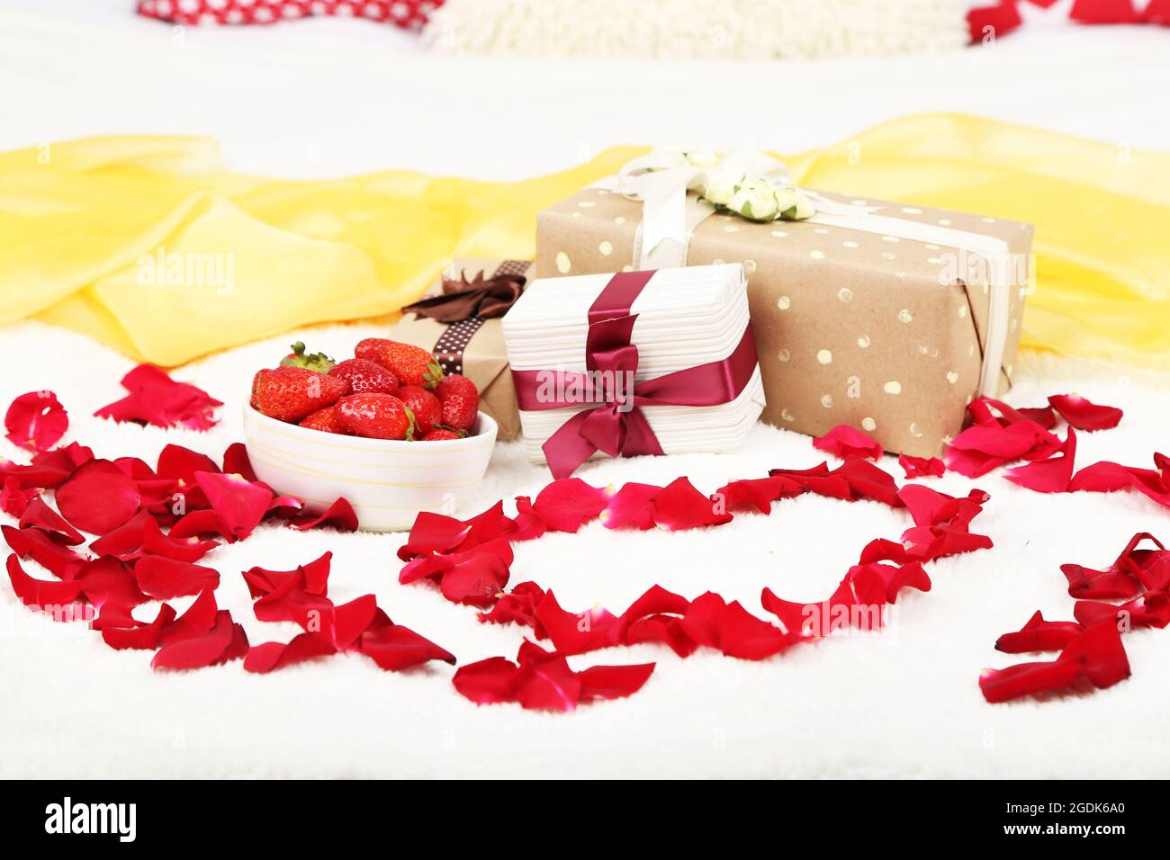 Romantic still life with strawberry, gift boxes and petals of roses on ...