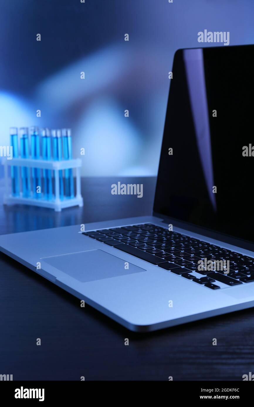 Laptop with test tubes in a laboratory on blue background Stock Photo ...