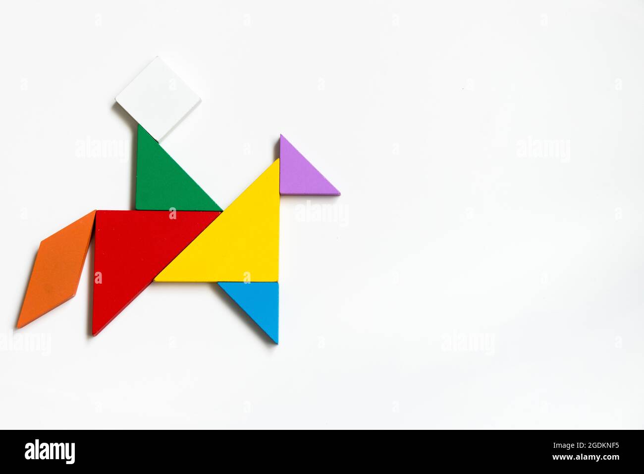 Colorful wood tangram puzzle in man riding horse shape on white ...