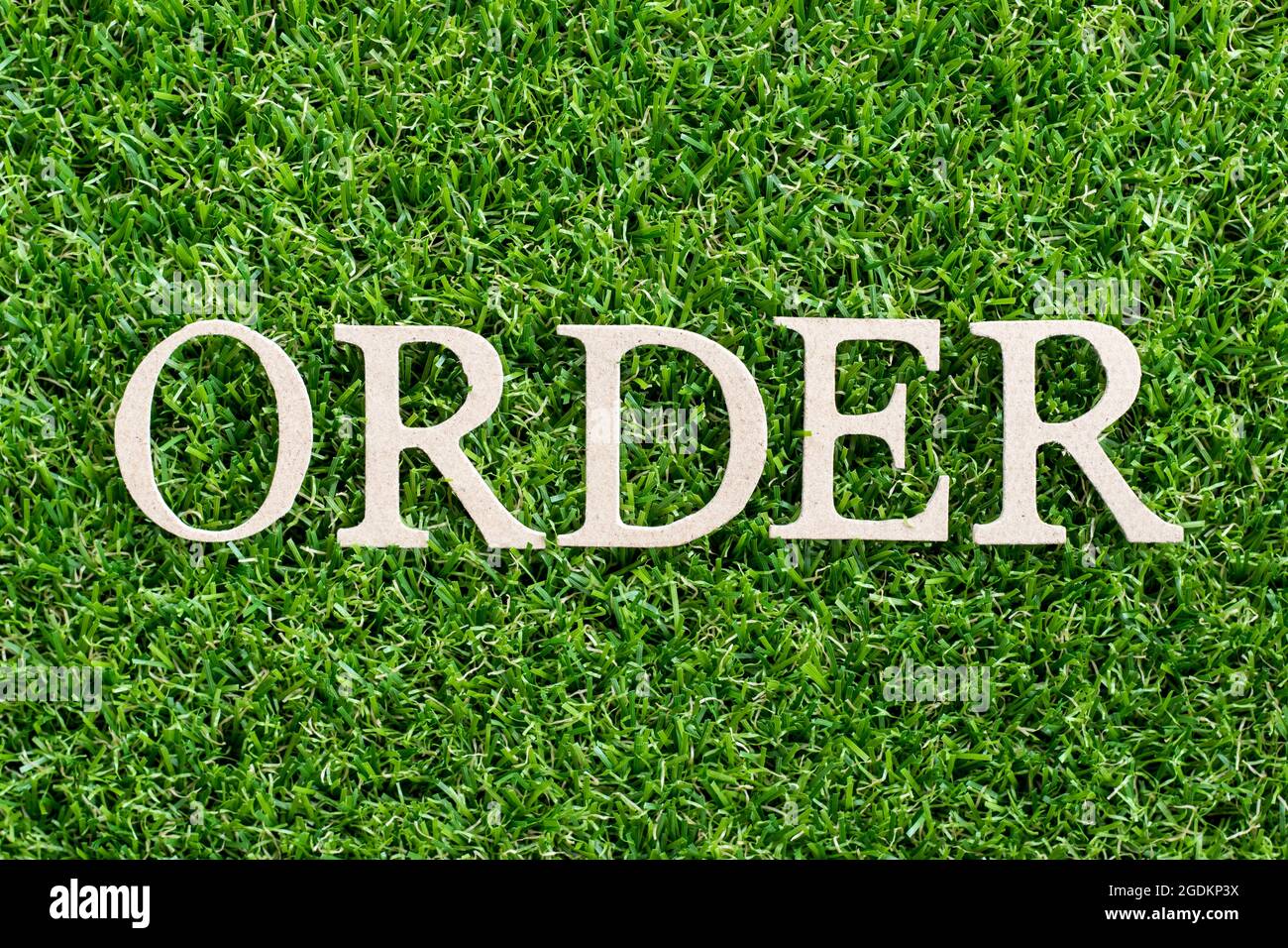 Wood letter in word order on artificial green grass background Stock ...