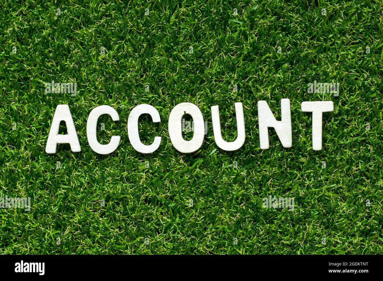 Wood alphabet in word account on artificial green grass background ...