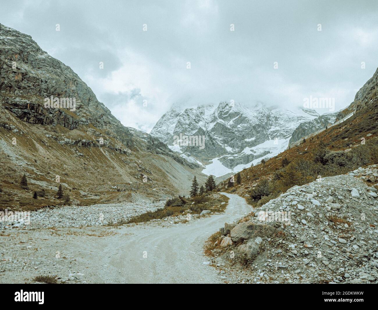 drone view over a desolate receding alpine glacier surrounded by ...