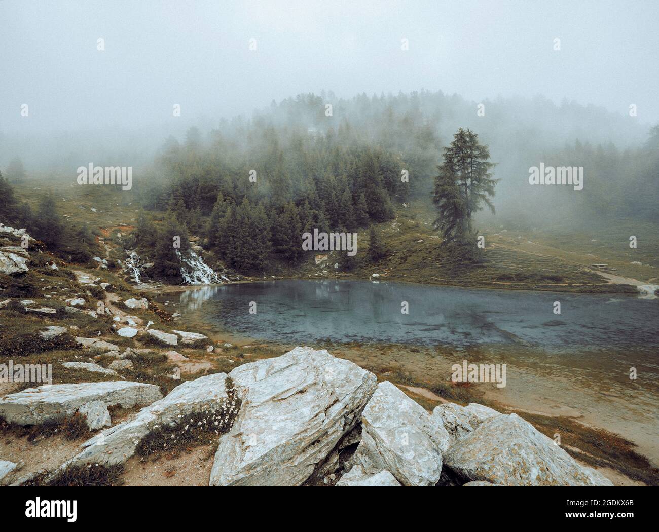 drone view over a desolate receding alpine glacier surrounded by ...