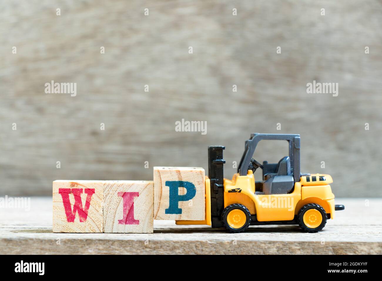 Toy forklift hold letter block P in word WIP (abbreviation of work in ... Toy forklift hold letter block P in word WIP (abbreviation of work in ...