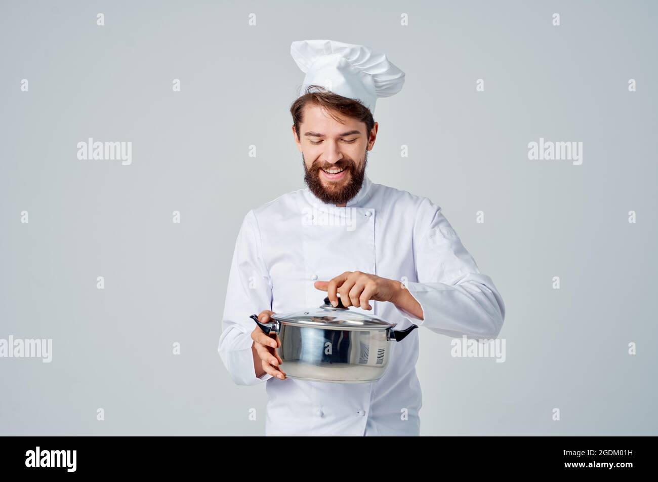 Cheerful male chef with a saucepan in his hands cooking food kitchen ...