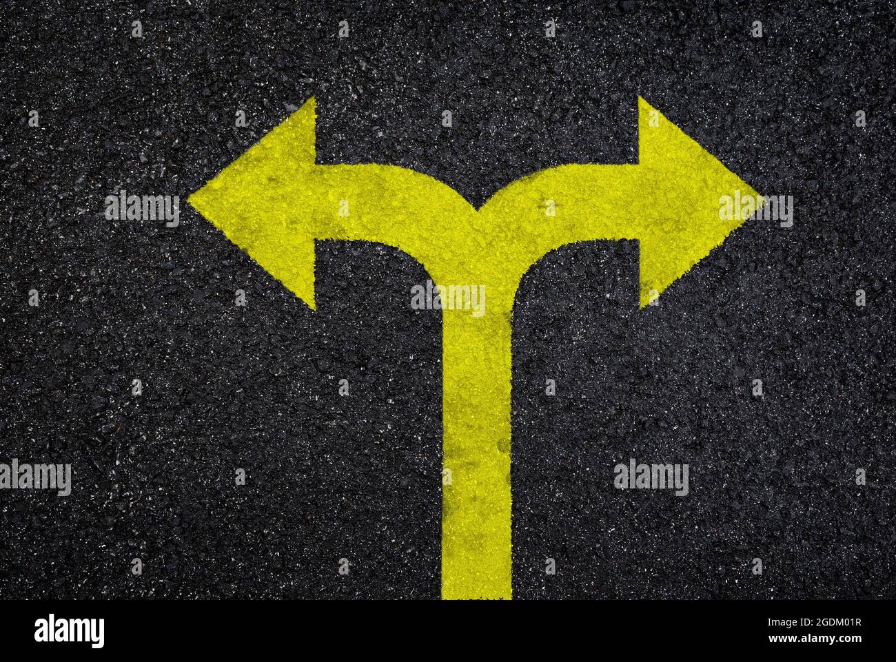 Yellow arrows pointing opposite directions on dark wet black asphalt ...