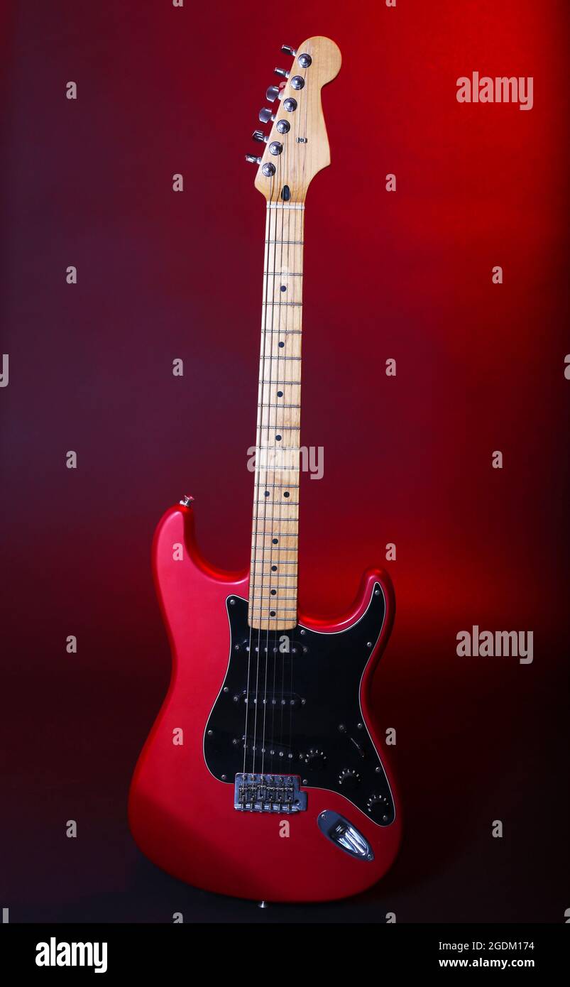 Red guitar on dark background Stock Photo - Alamy