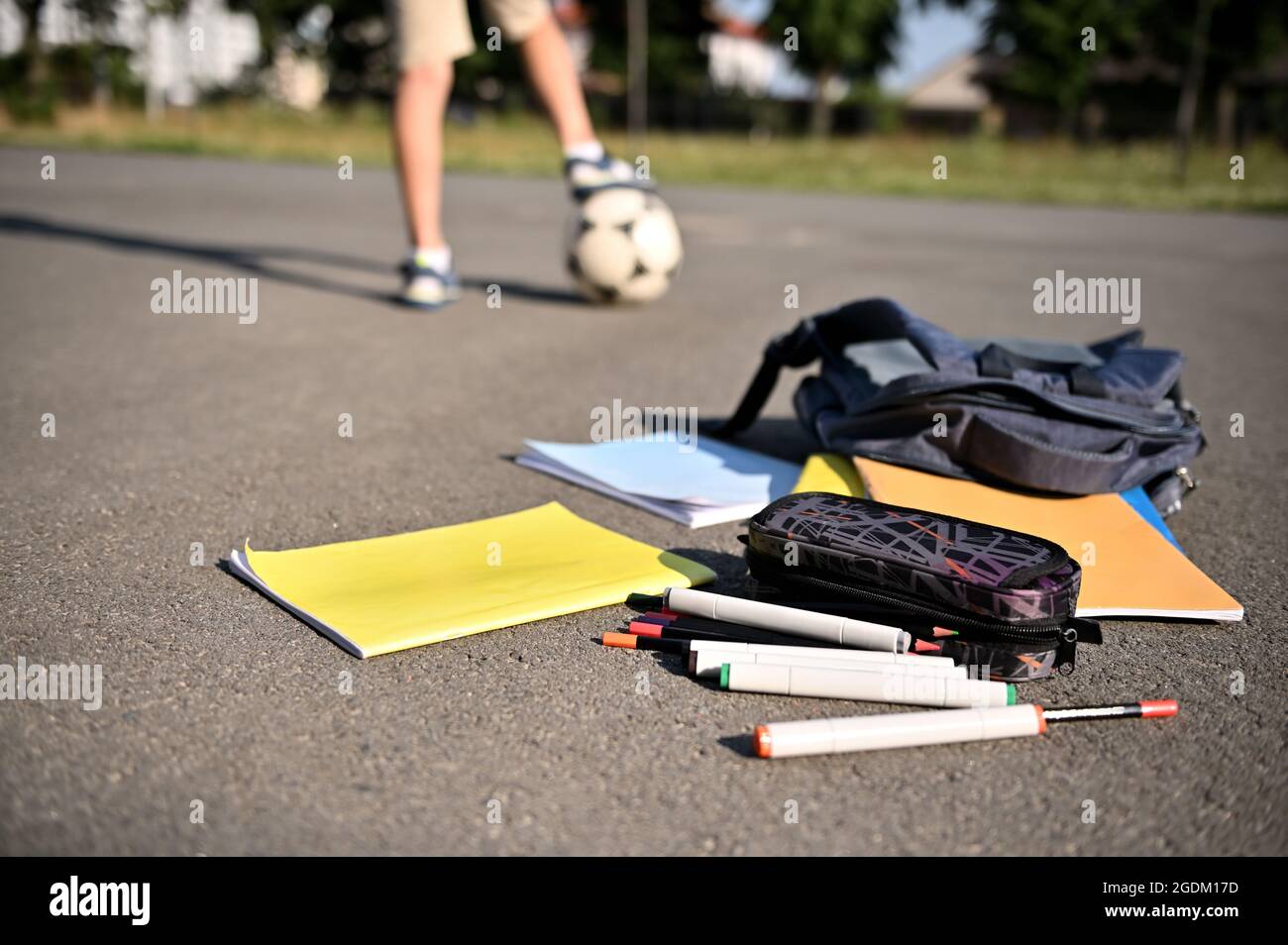 Scattered school supplies and workbooks falling out of an open backpack ...