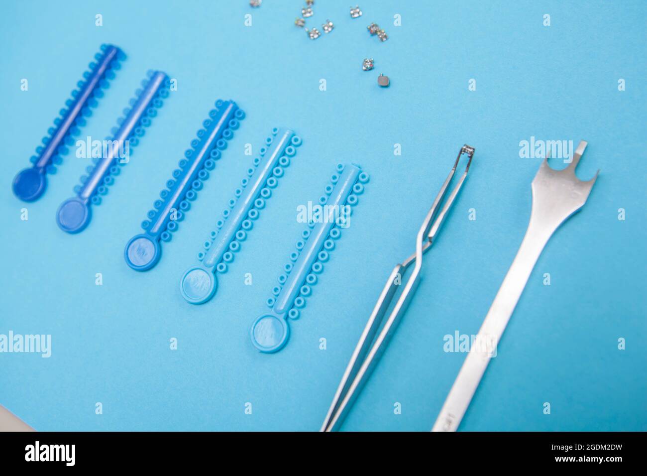 Braces elastics and dental instruments on blue background Stock Photo ...