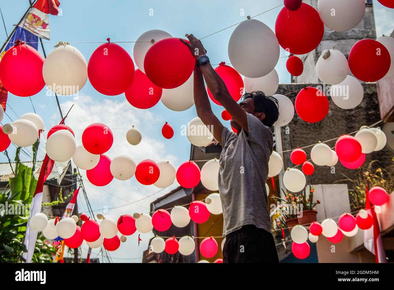 A man sets up red and white balloons from the colours of the Indonesian ...