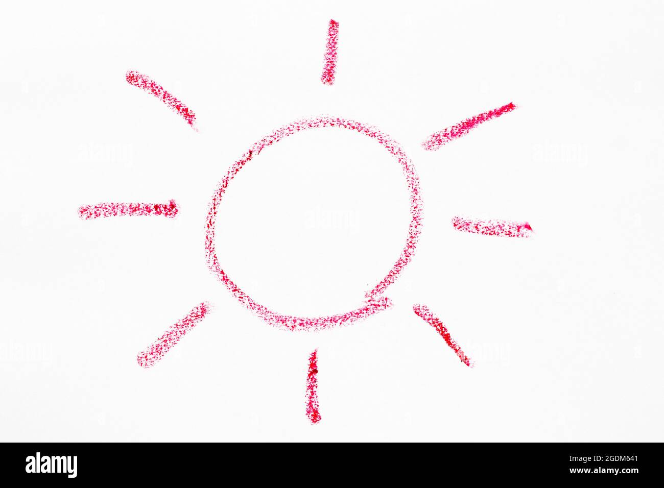 Red oil pastel drawing in sun with ray shape on white paper background ...