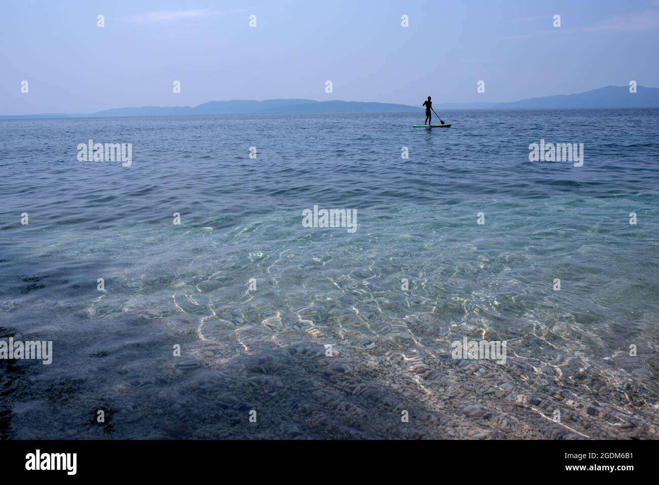 a man while stand-up-padding on the sea Stock Photo - Alamy