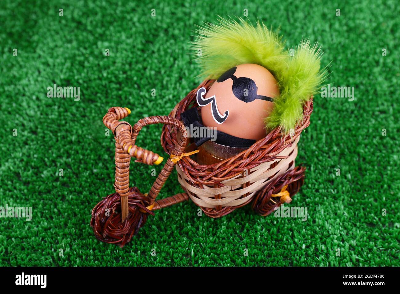 Egg riding bicycle on green background Stock Photo - Alamy