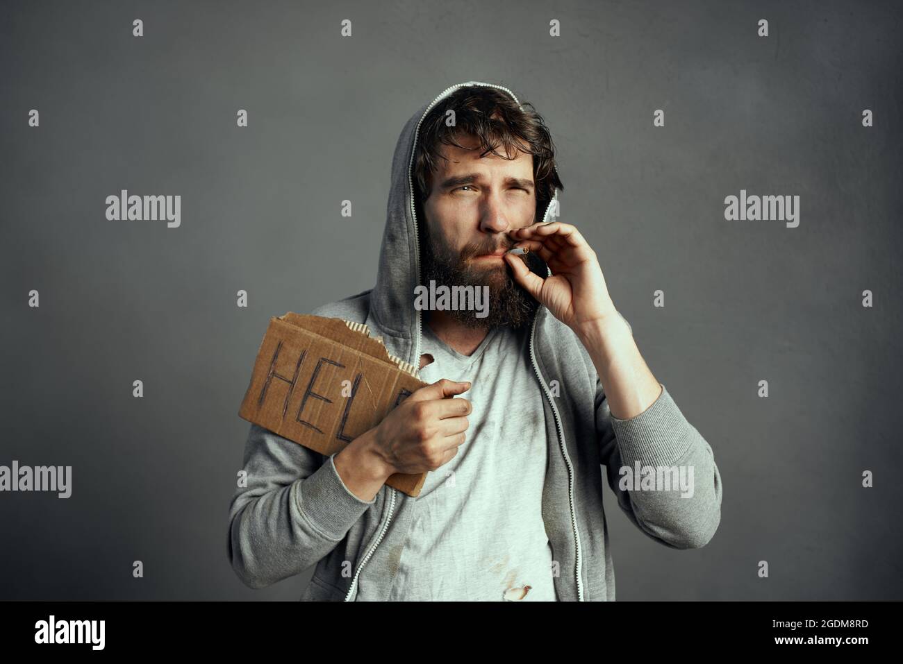 homeless bearded man tramp with cigarette sign help Stock Photo - Alamy
