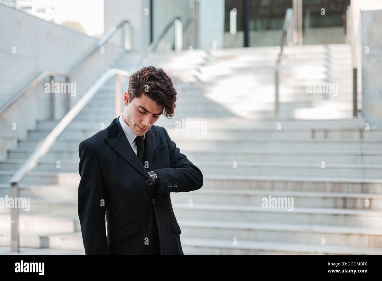 Serious young Caucasian guy dressed professionally taking something ...