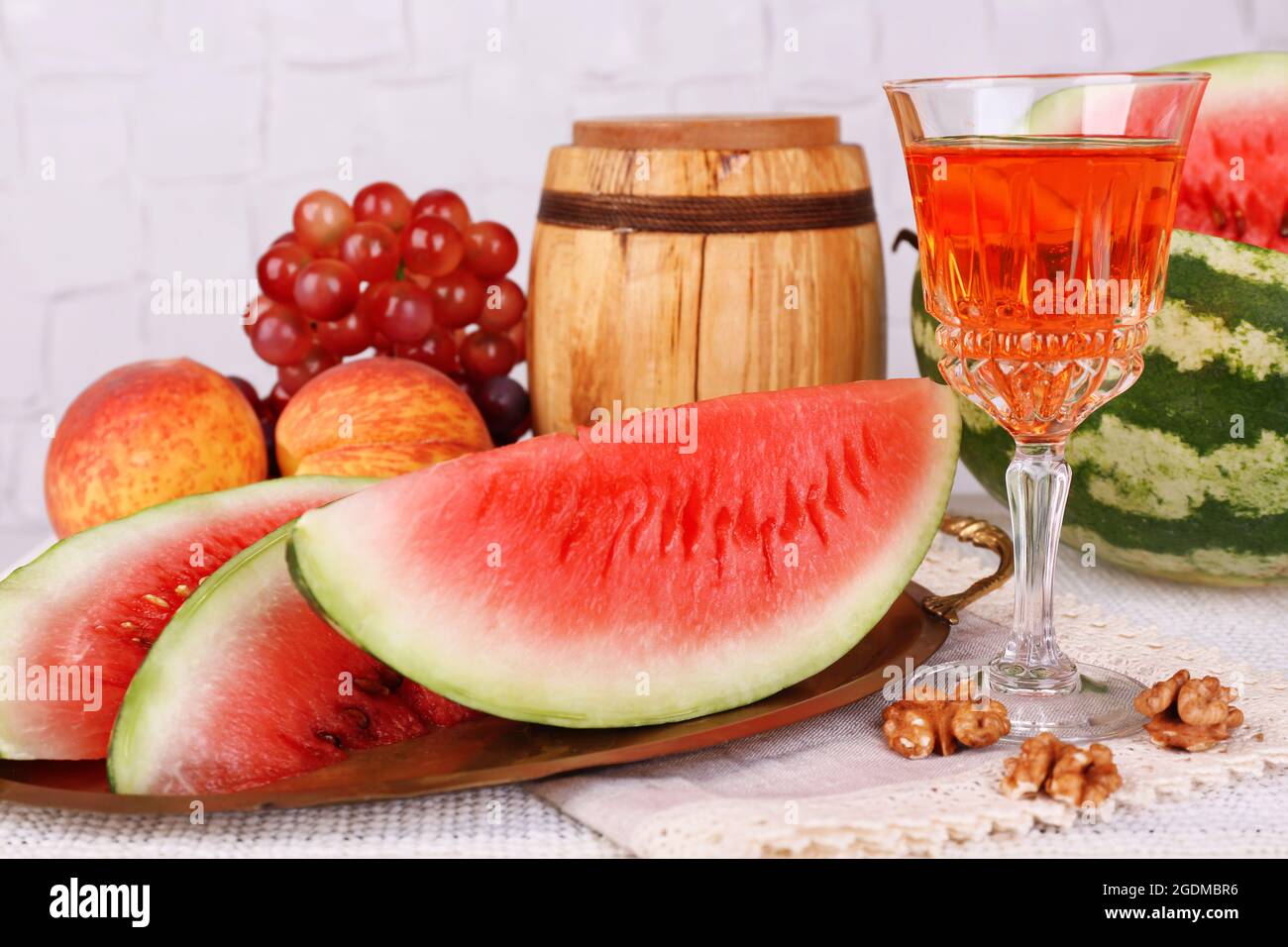 Composition of ripe watermelon, fruits, pink wine in glass and wooden ...