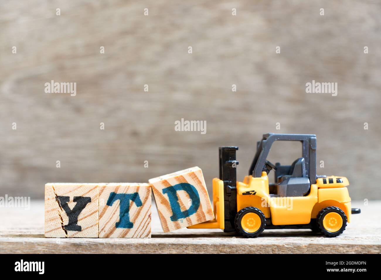 Toy forklift hold letter block Y in word YTD (abbreviation of year to ...