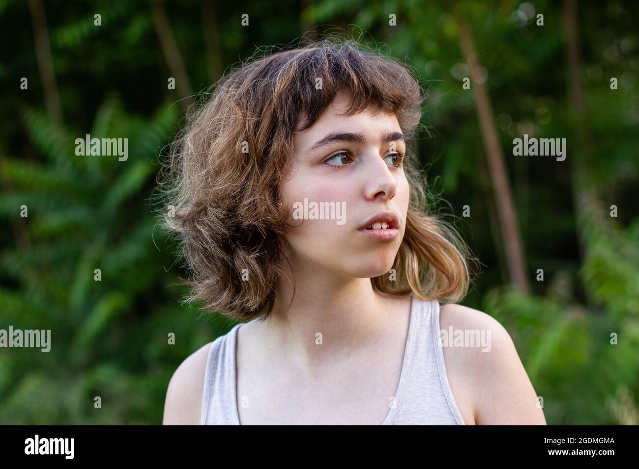 Serious teenager girl looking angry. Curly young girl outside Stock ...