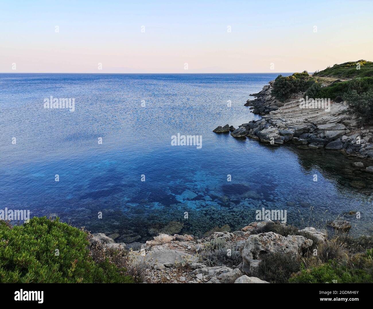 Sunset on sea with surrounding rock stone formations Stock Photo - Alamy