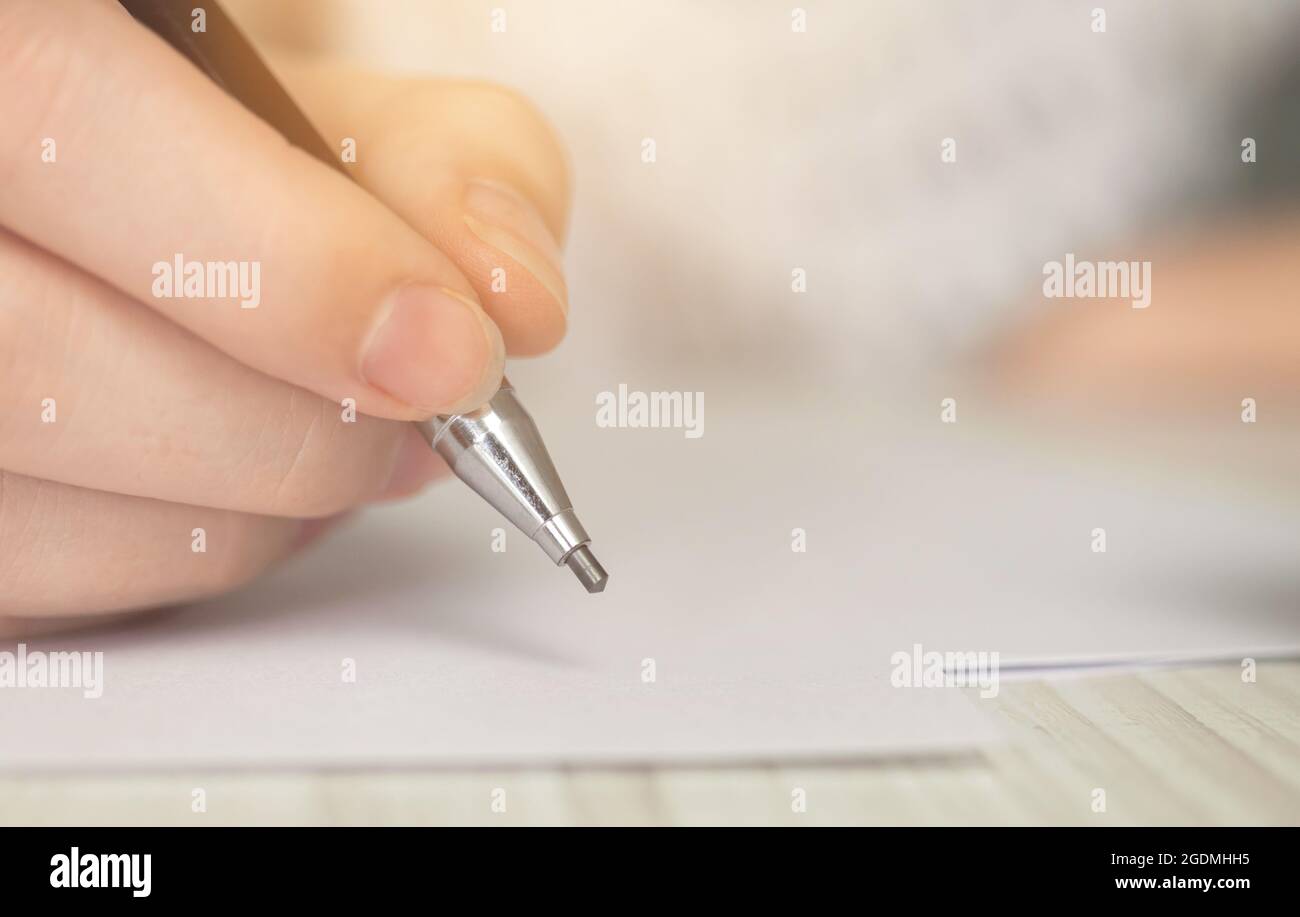 Close-up hand writing, on wooden table. Education, learning and ...
