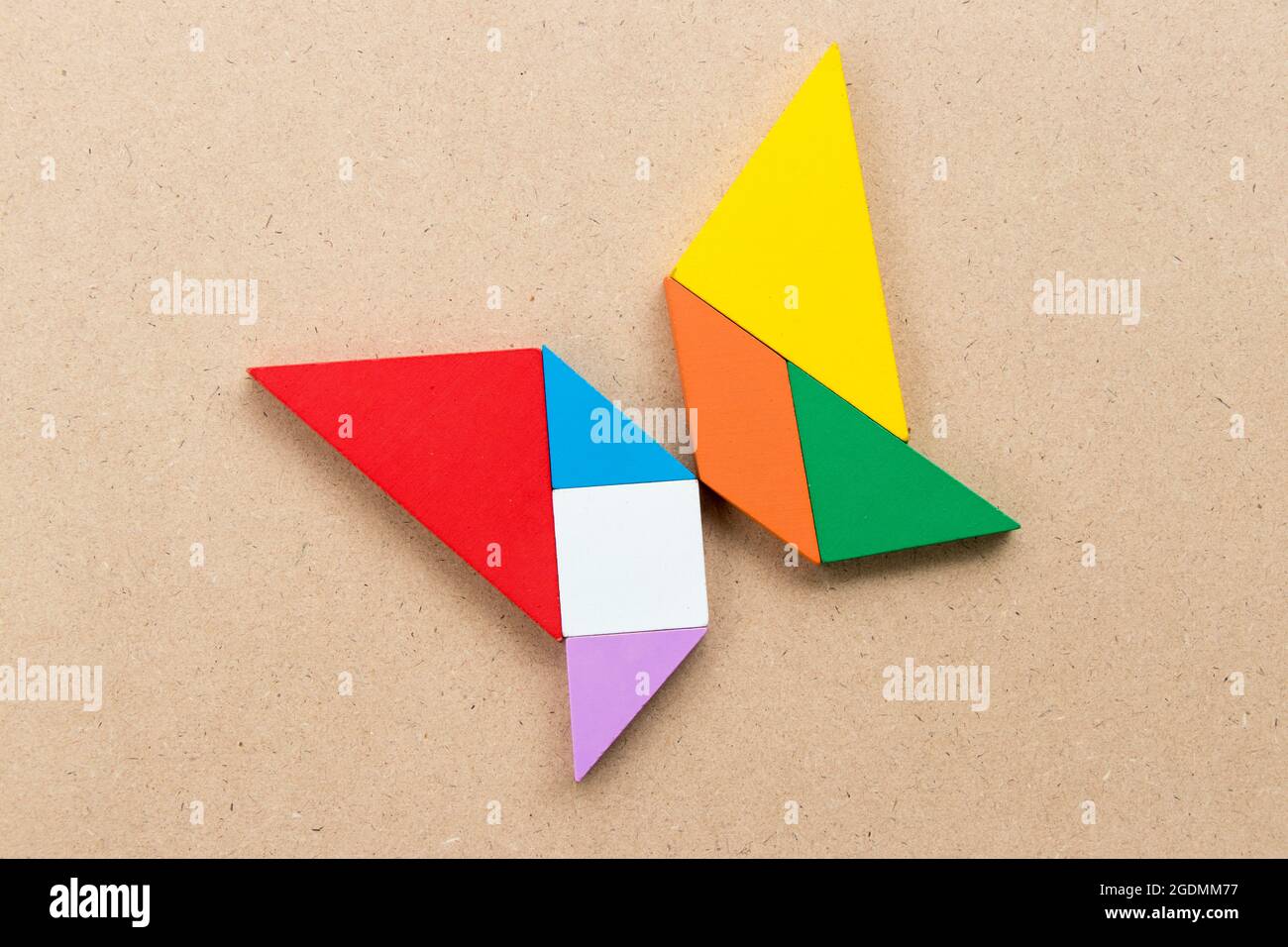 Color tangram puzzle in butterfly shape on wood background Stock Photo ...
