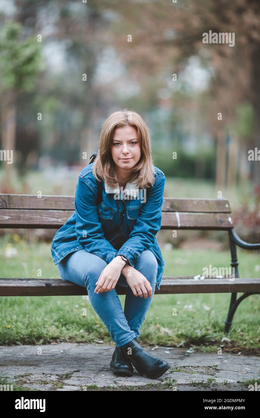 Shallow focus closeu shot of a young blonde woman sitting on a wooden ...