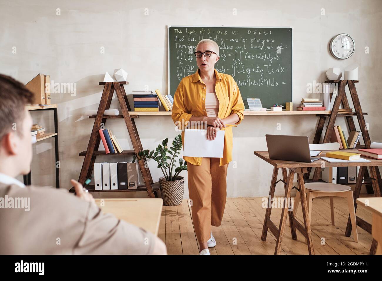 Teacher walking through the classroom and explaining the materialto ...