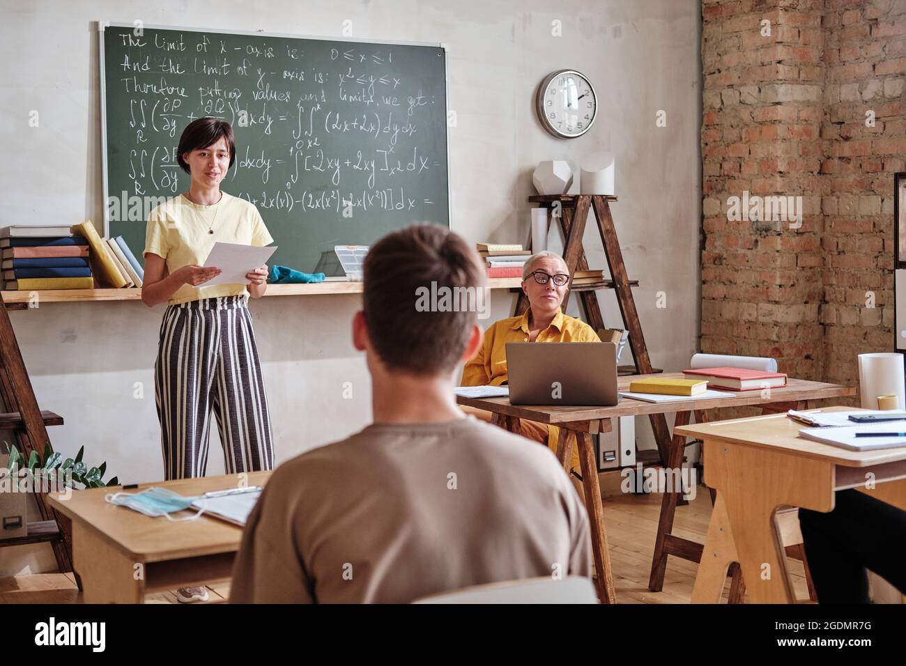 Student presenting her report to teacher and her classmates during ...