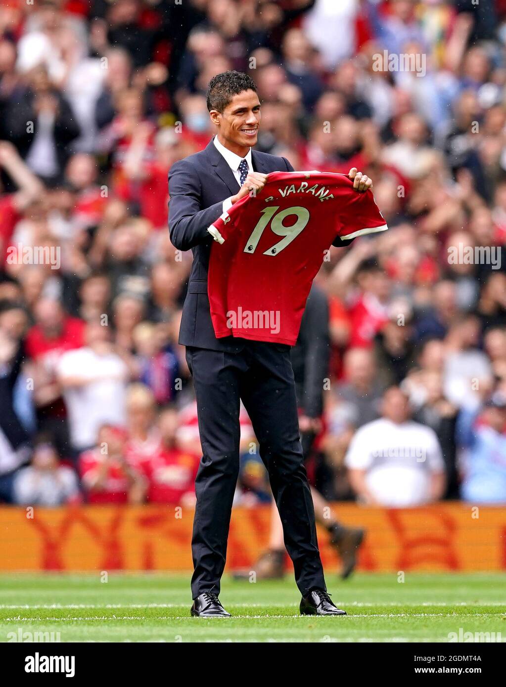 Manchester United's Raphael Varane holds up his shirt on the pitch as ...