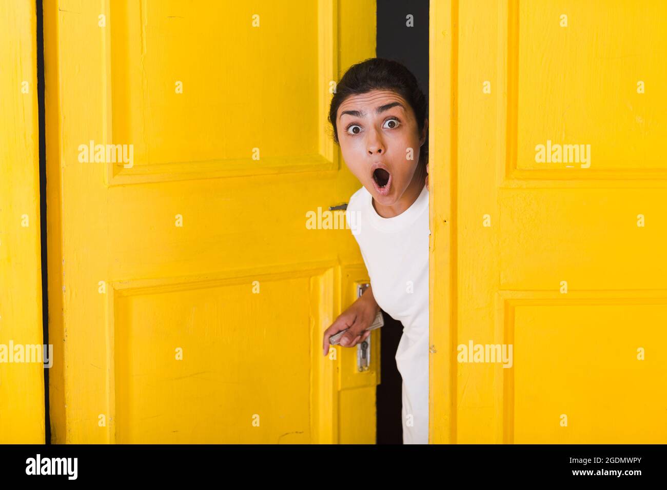 Woman peeking into room hi-res stock photography and images - Alamy