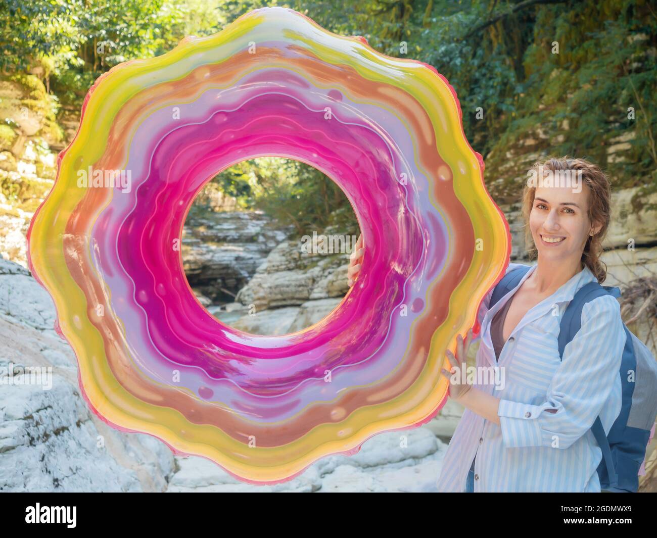 A bright multicolored inflatable circle in the hands of joyful girl ...