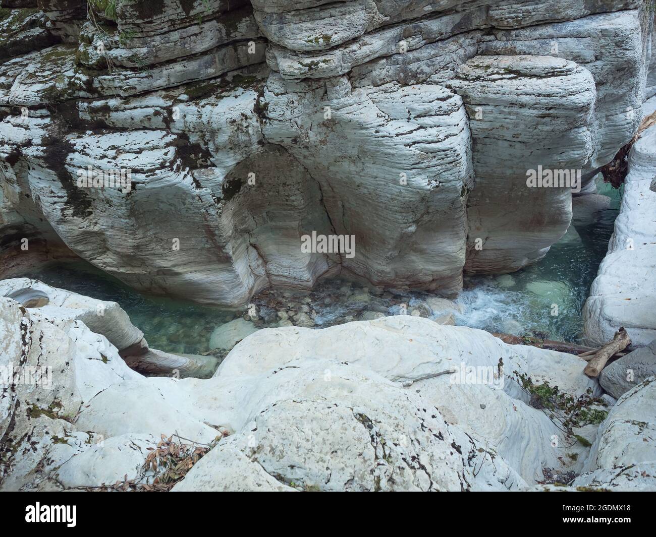 A calm, transparent river flows between massive steep canyons Stock ...