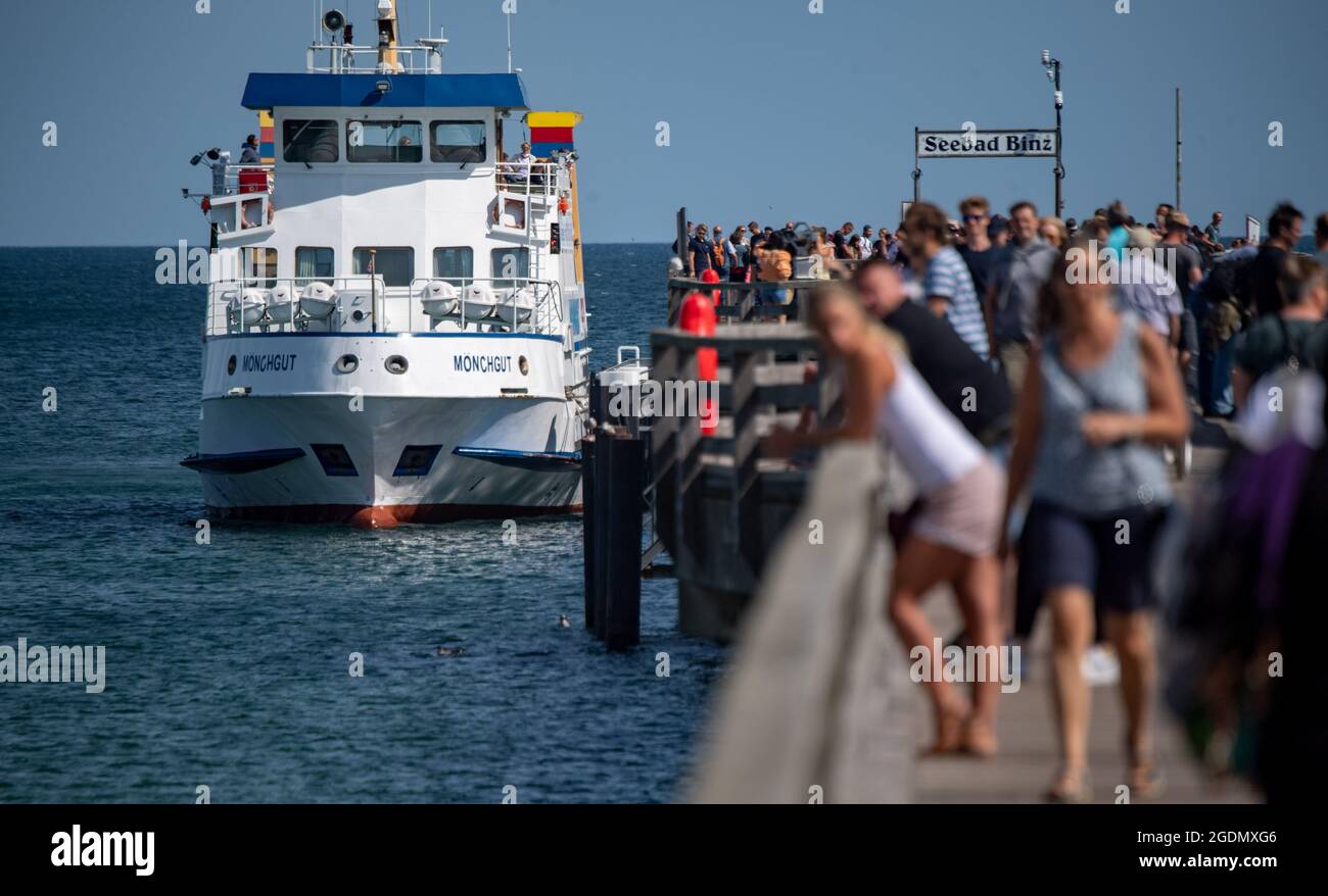 Binz, Germany. 14th Aug, 2021. Locals and tourists walk across the pier ...