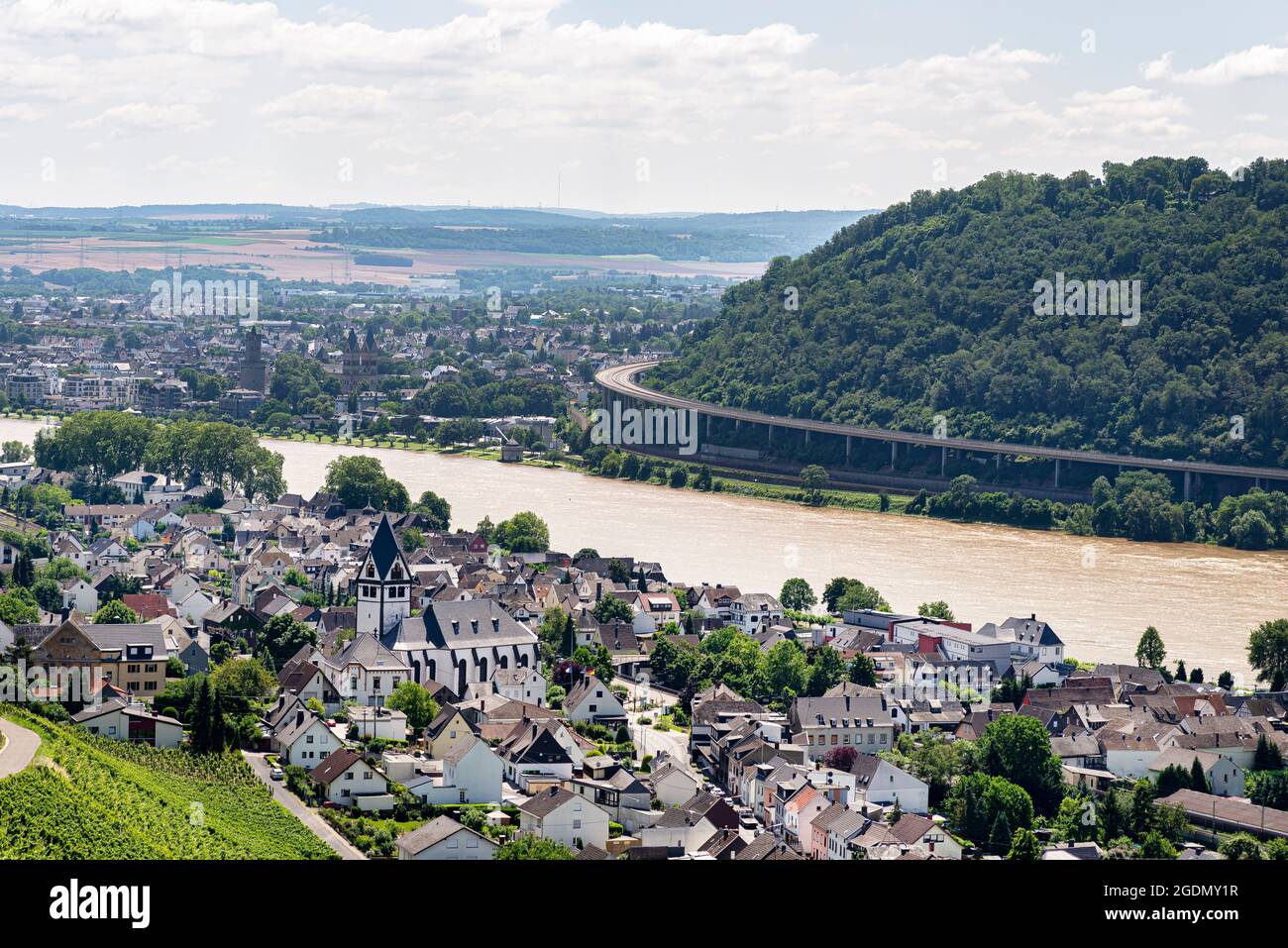 The river Rhine flows between the village and the forest covered hills ...