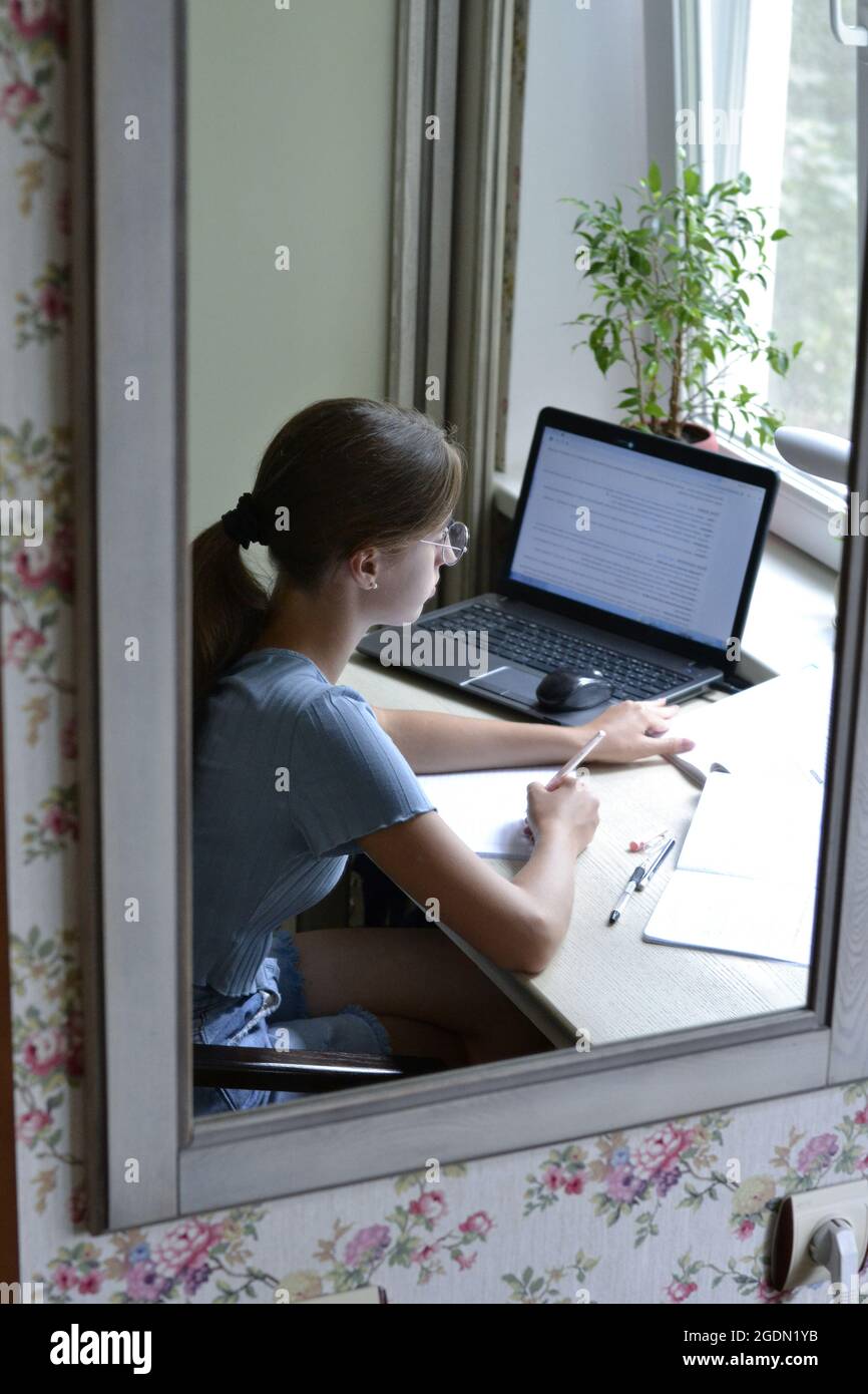 reflection in the mirror girl doing homework Stock Photo - Alamy
