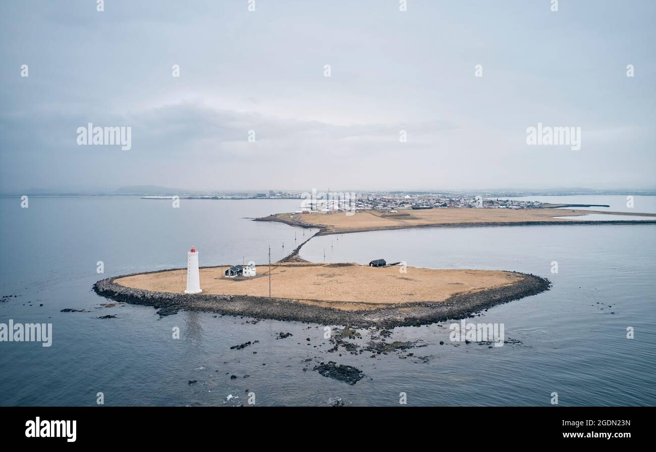 Aerial view of small island with white beacon tower and house located ...