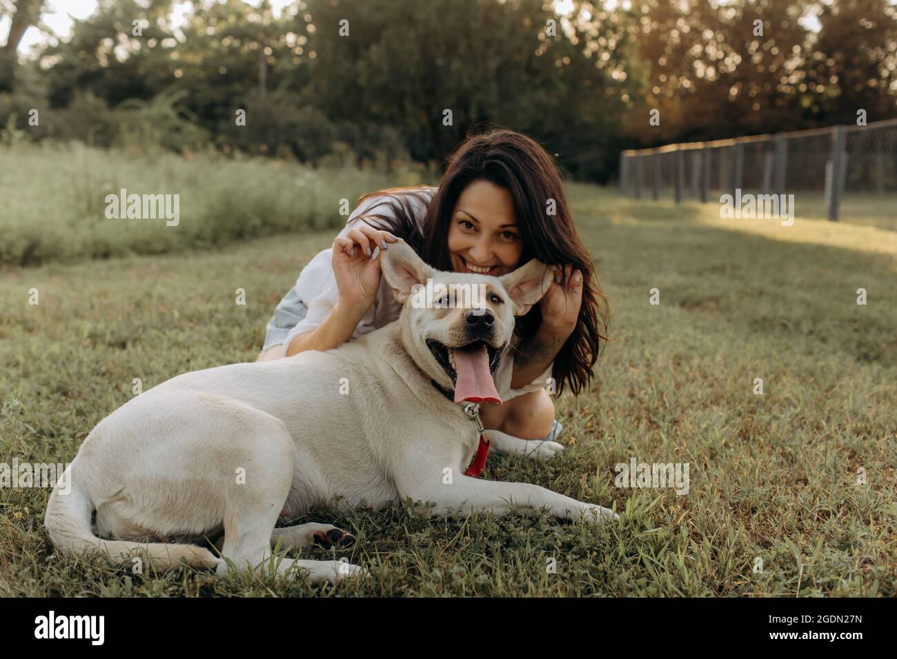 Happy woman hugging and having fun with her Labrador puppy outdoors ...