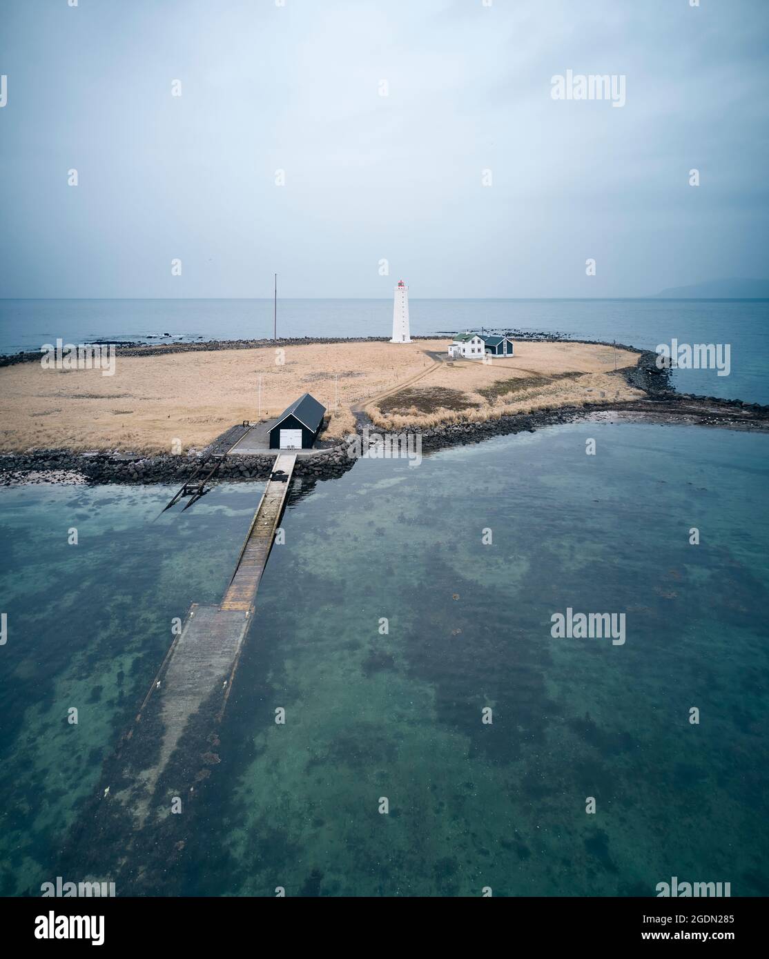 Aerial view of sandy island with houses and white lighthouse located in ...