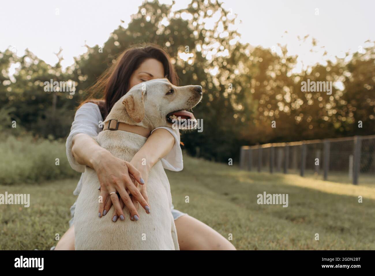 Happy woman hugging her Labrador puppy outdoors Stock Photo - Alamy