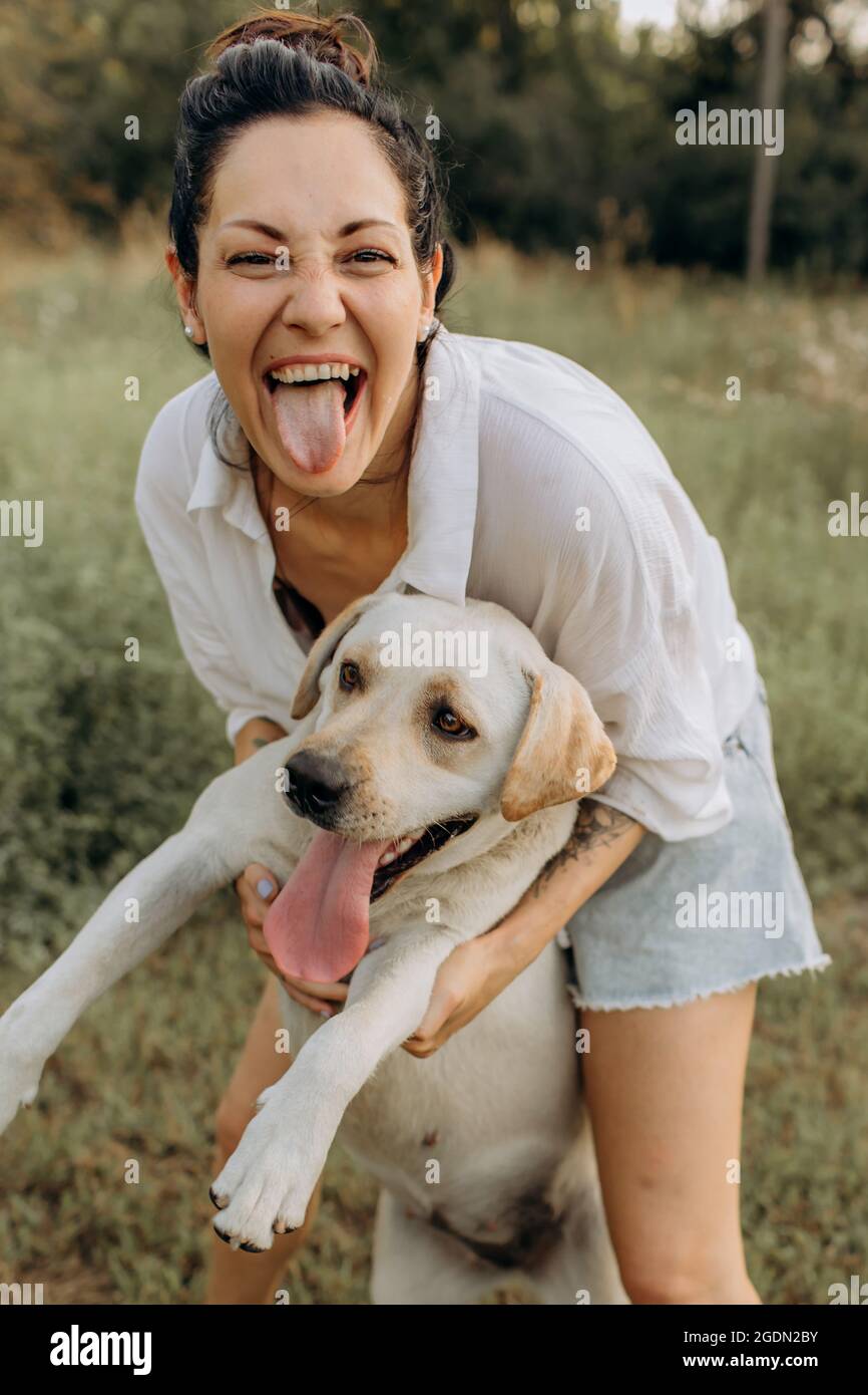 Happy woman hugging her Labrador puppy outdoors Stock Photo - Alamy