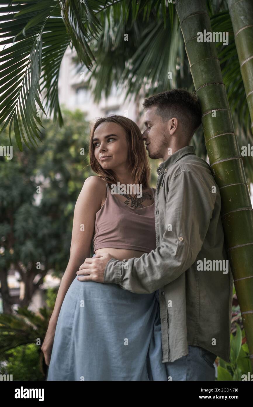 Portrait of romantic Couple standing in the park and cuddling. Wearing ...