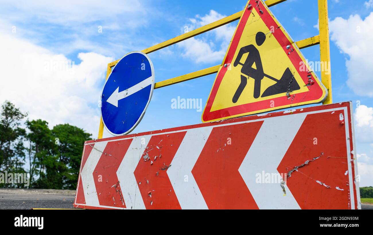 Road works sign on the road. Repair work of road signs and a bypass ...