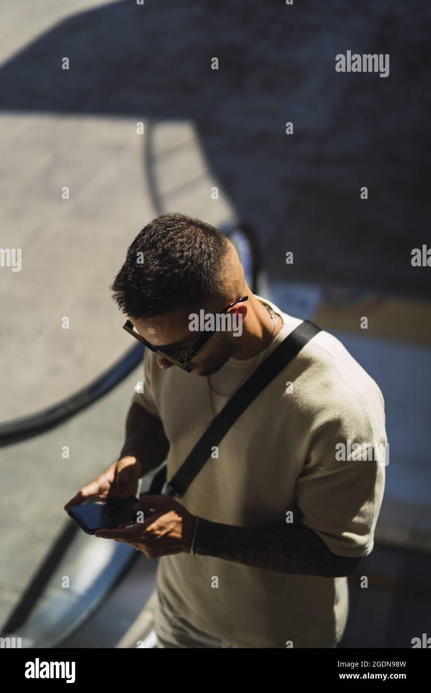 Man looking at his smartphone viewed from above with a blurred ...