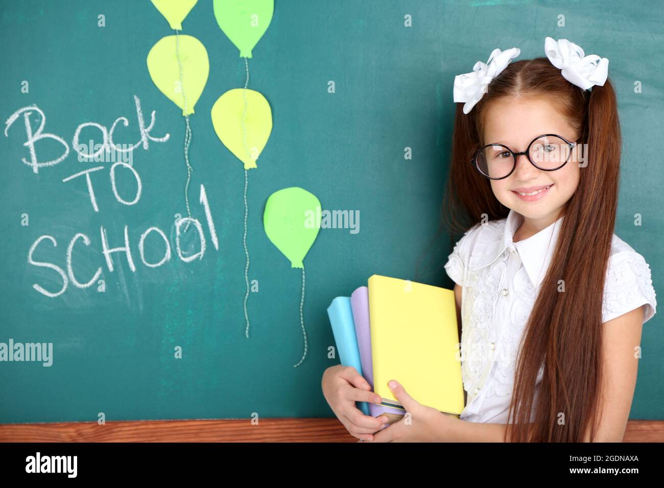 Cute girl standing near blackboard in classroom Stock Photo - Alamy