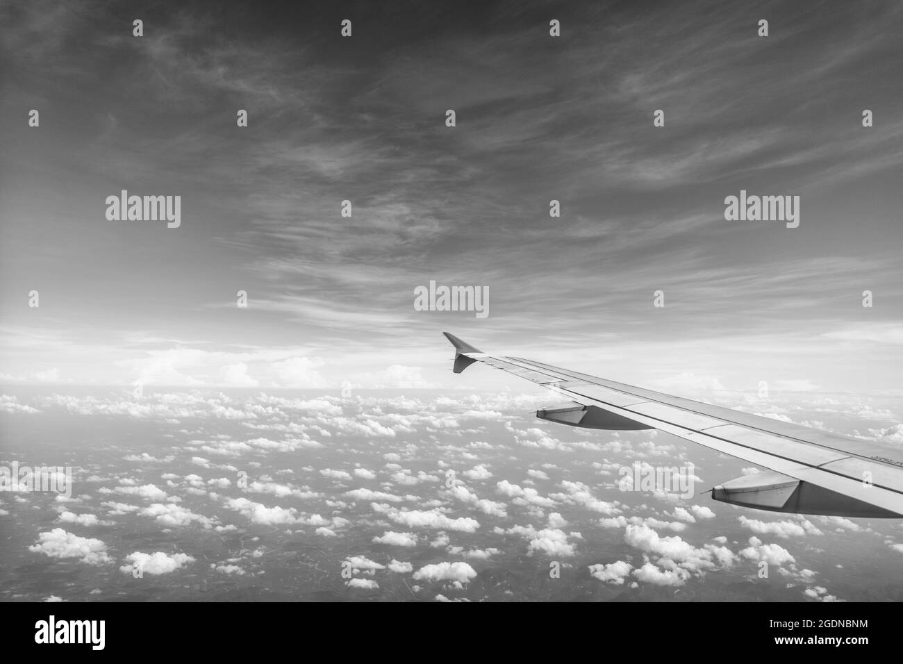 Grayscale shot of an airplane wing against cloudy blue sky Stock Photo ...