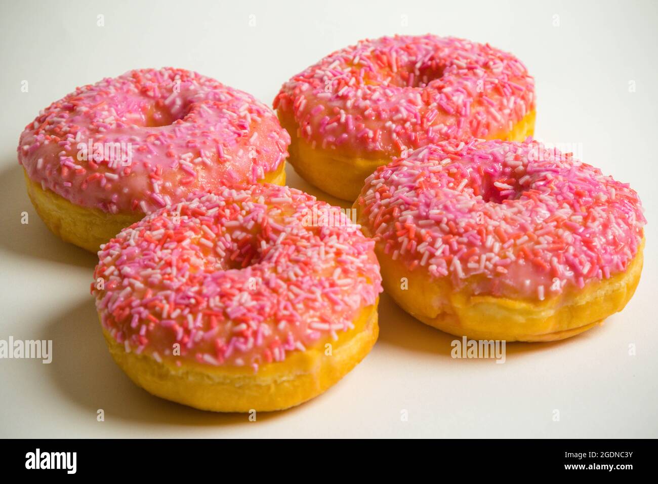 Four Iced Ring Donuts On A White Background Stock Photo - Alamy